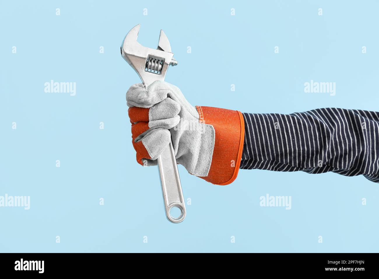 Female worker with wrench on blue background Stock Photo - Alamy