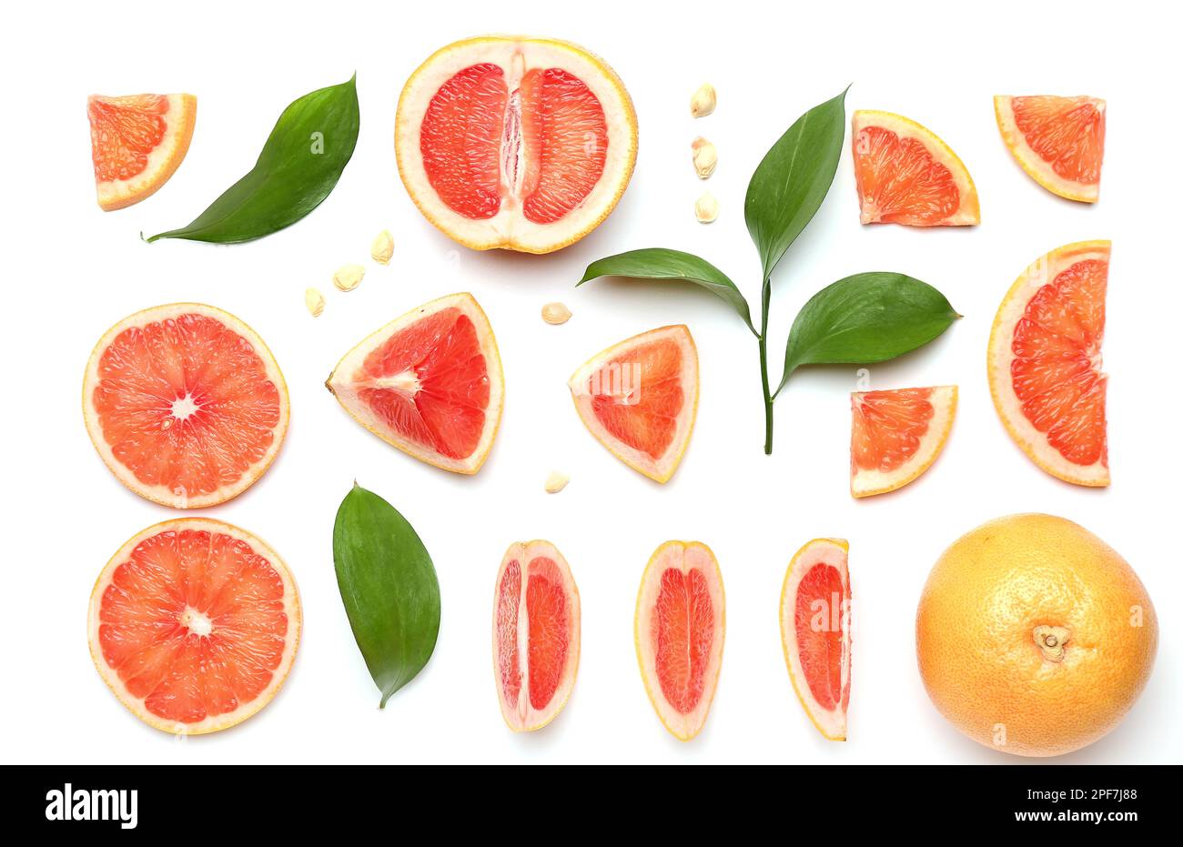 Composition with pieces of ripe grapefruit, seeds and plant leaves on ...
