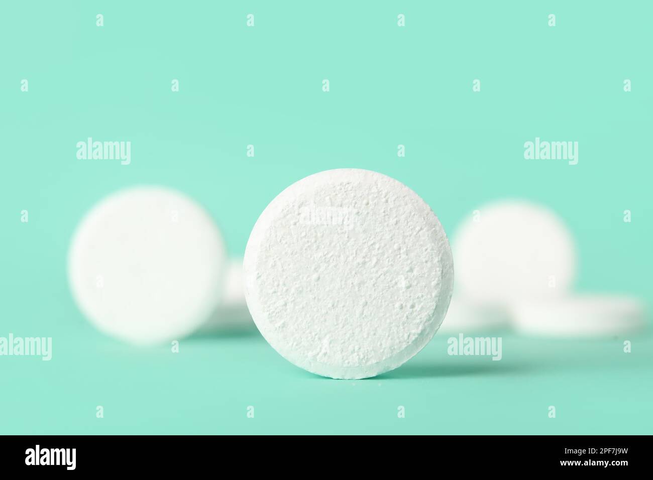White soluble tablets on turquoise background Stock Photo - Alamy