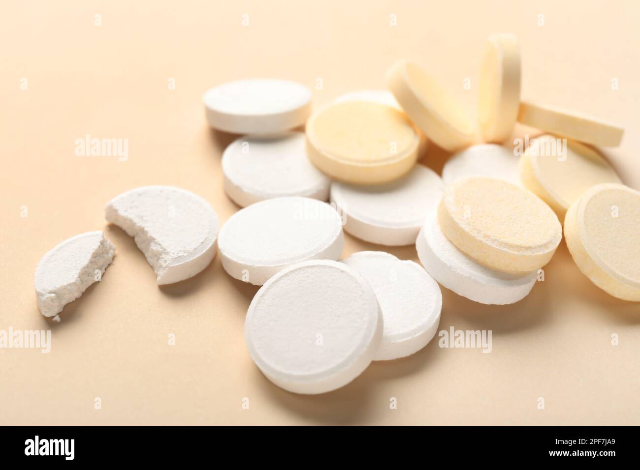 White and yellow soluble tablets on beige background Stock Photo - Alamy