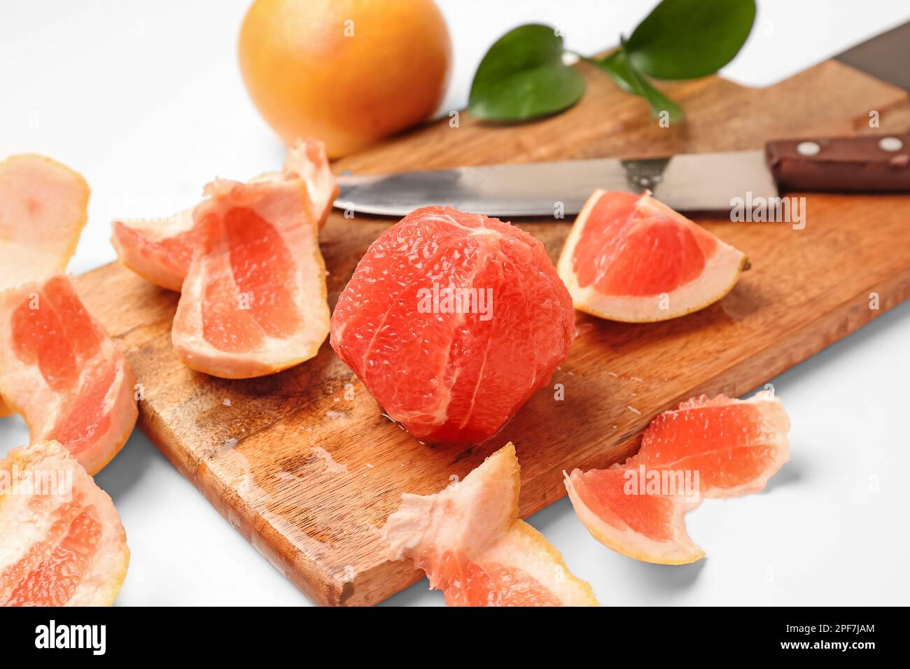 Wooden board with peeled grapefruit on white background, closeup Stock ...