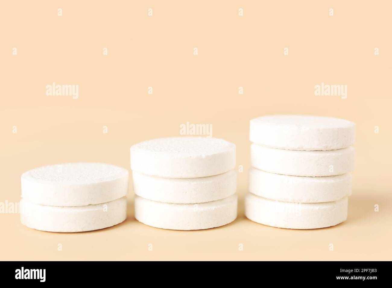 Stacks of white soluble tablets on beige background Stock Photo - Alamy