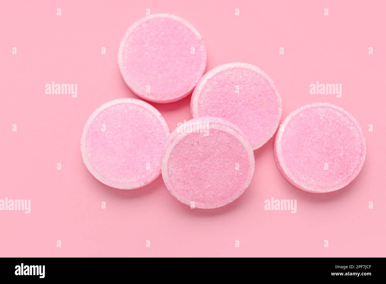 Soluble tablets on pink background Stock Photo - Alamy