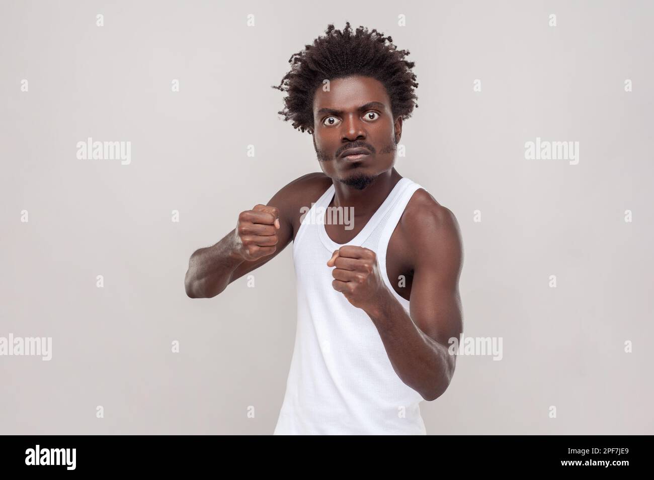 Displeased impassionate man fighting with someone, looking at camera ...