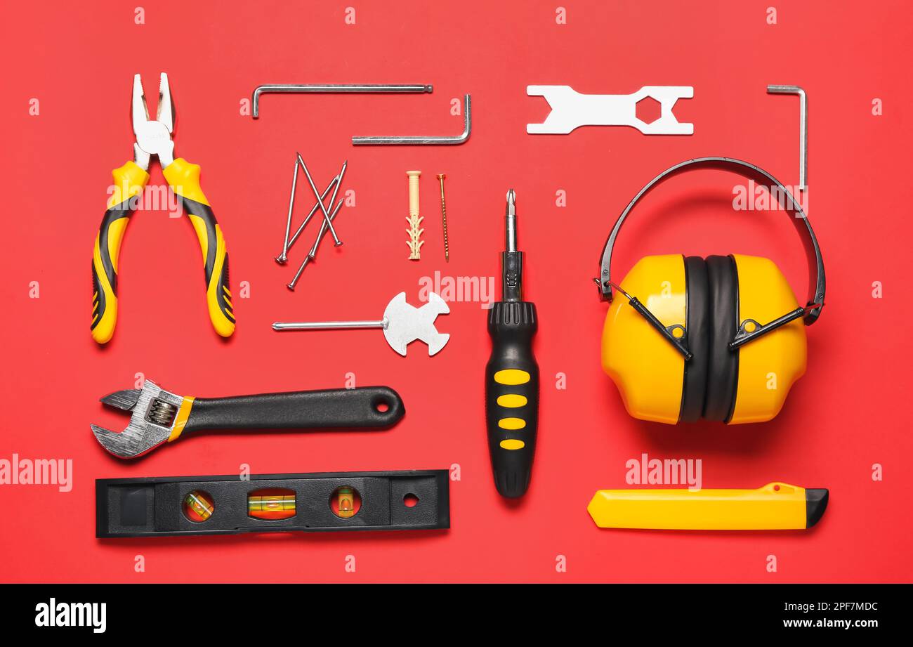 Different construction tools on red background Stock Photo - Alamy