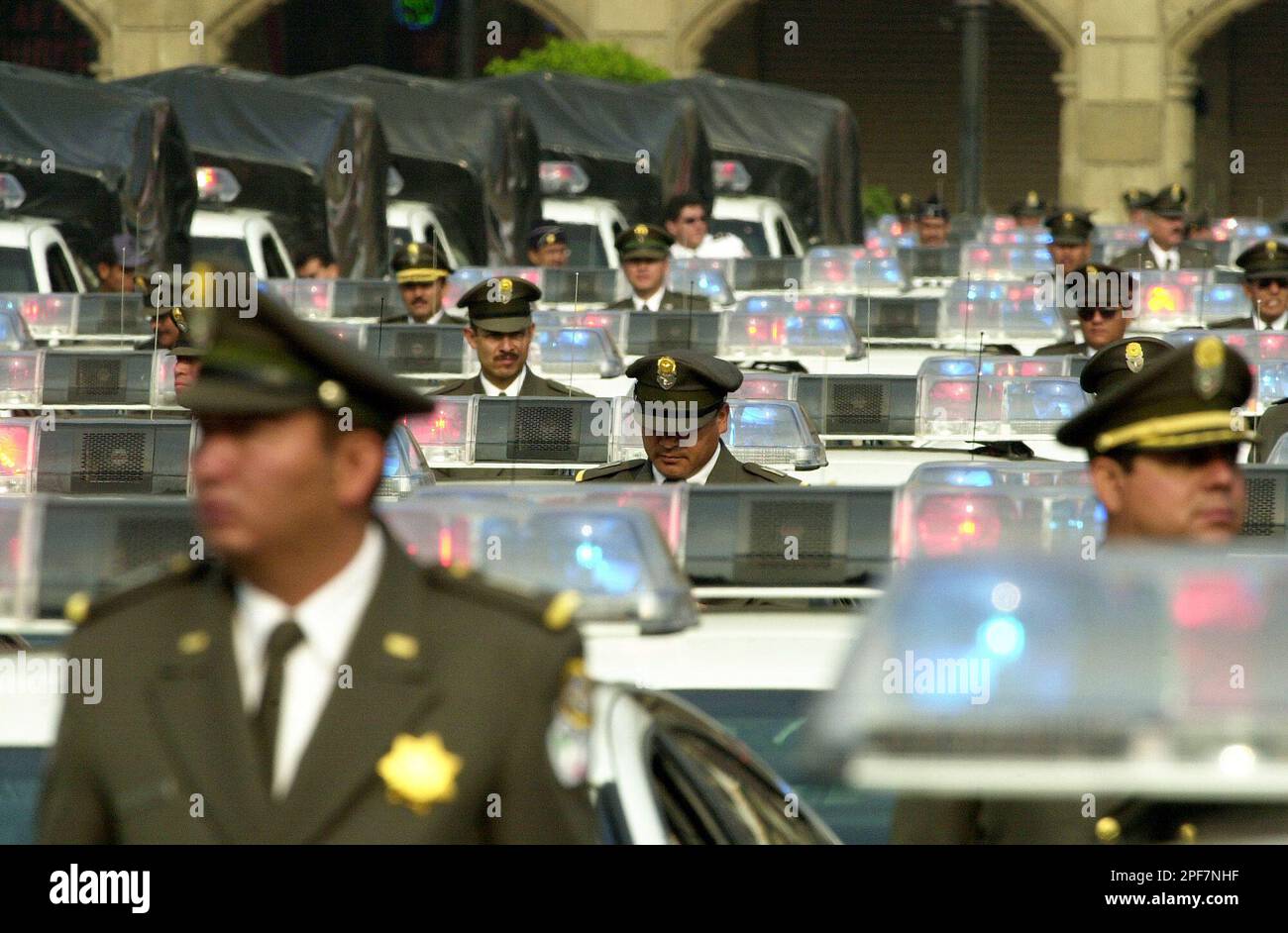 Mexican Federal Police officers stand next to new patrol cars at Zocalo ...