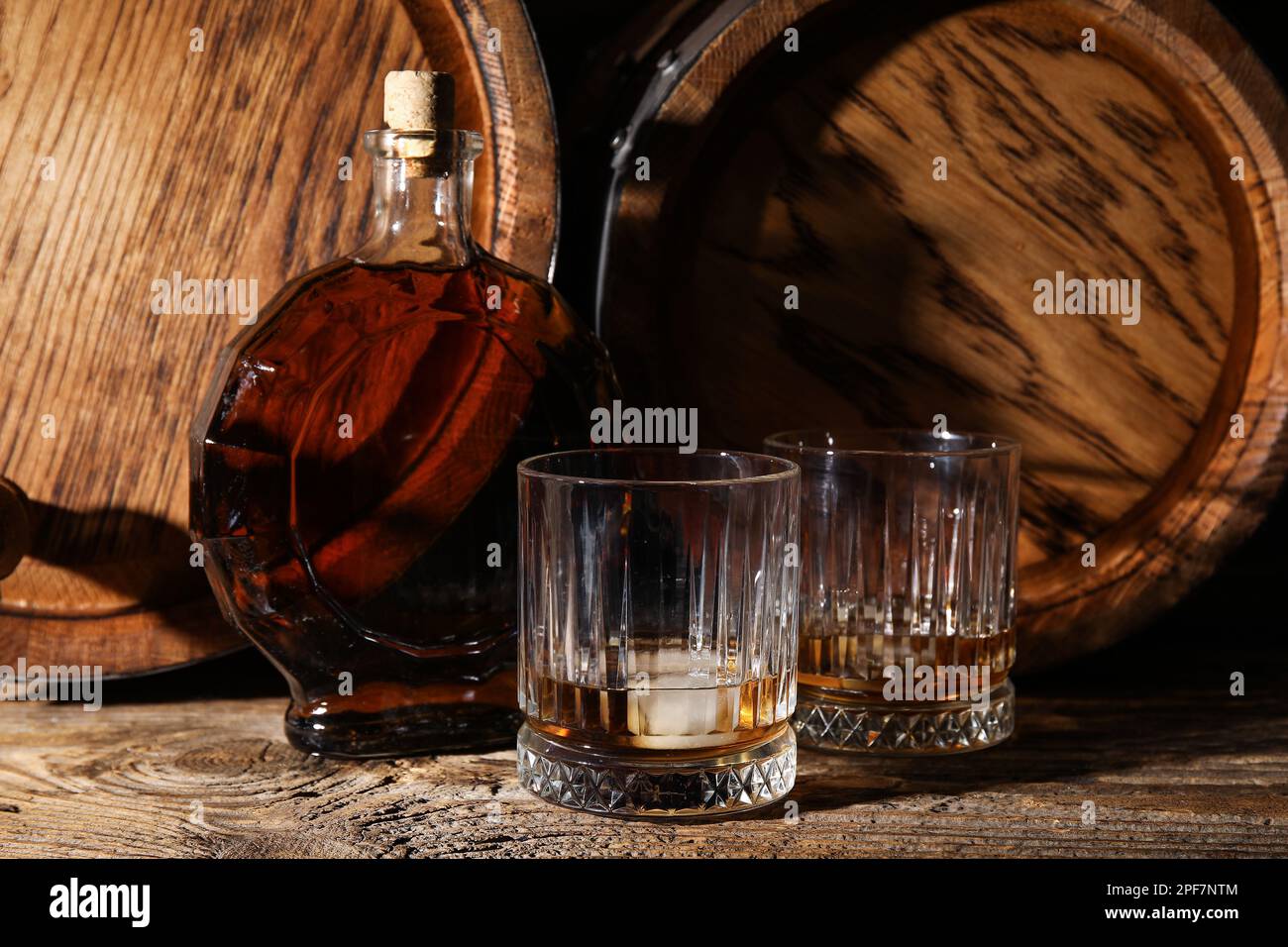 Oak barrels with bottle and glasses of cold whiskey on table Stock ...