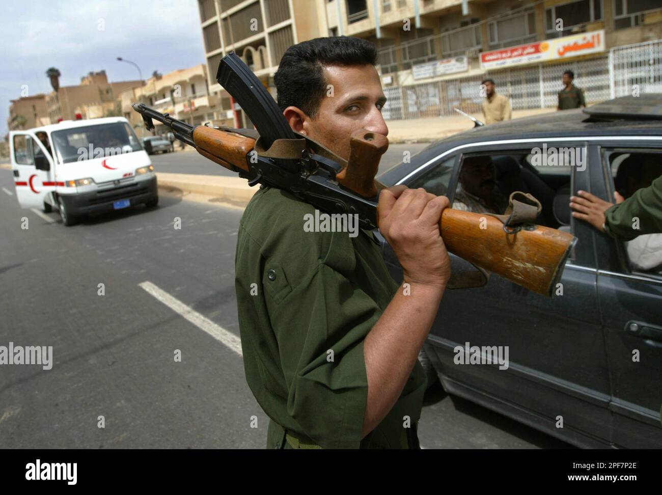 An Iraqi police officer holds his AK-47 automatic rifle as he and other ...