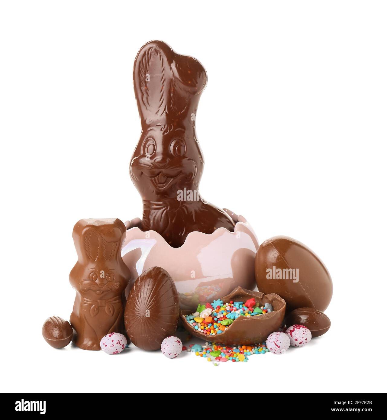 Chocolate Easter bunnies with eggs and sprinkles on white background ...