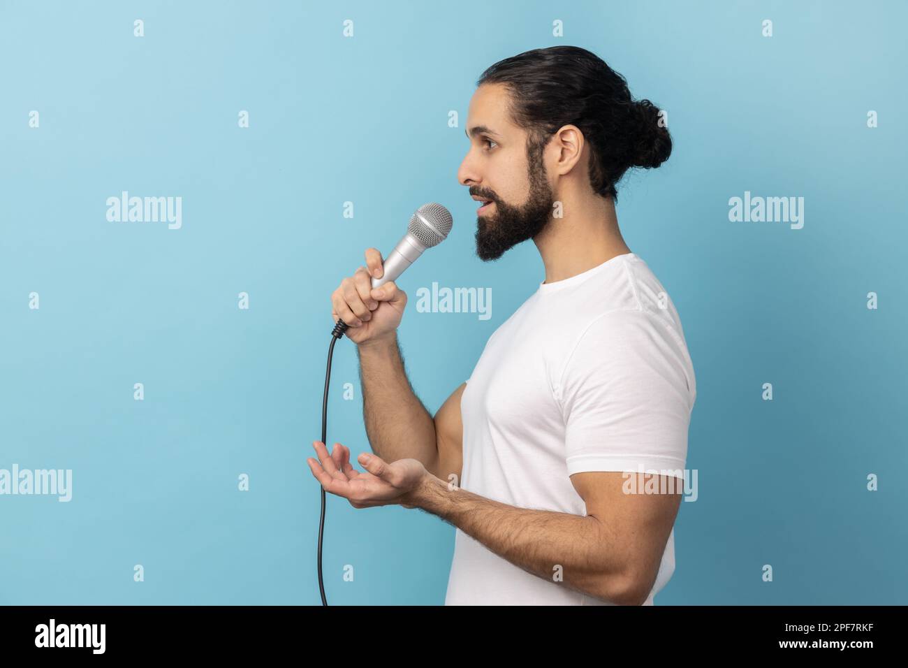 Side view of serious man with beard wearing white T-shirt, journalist ...