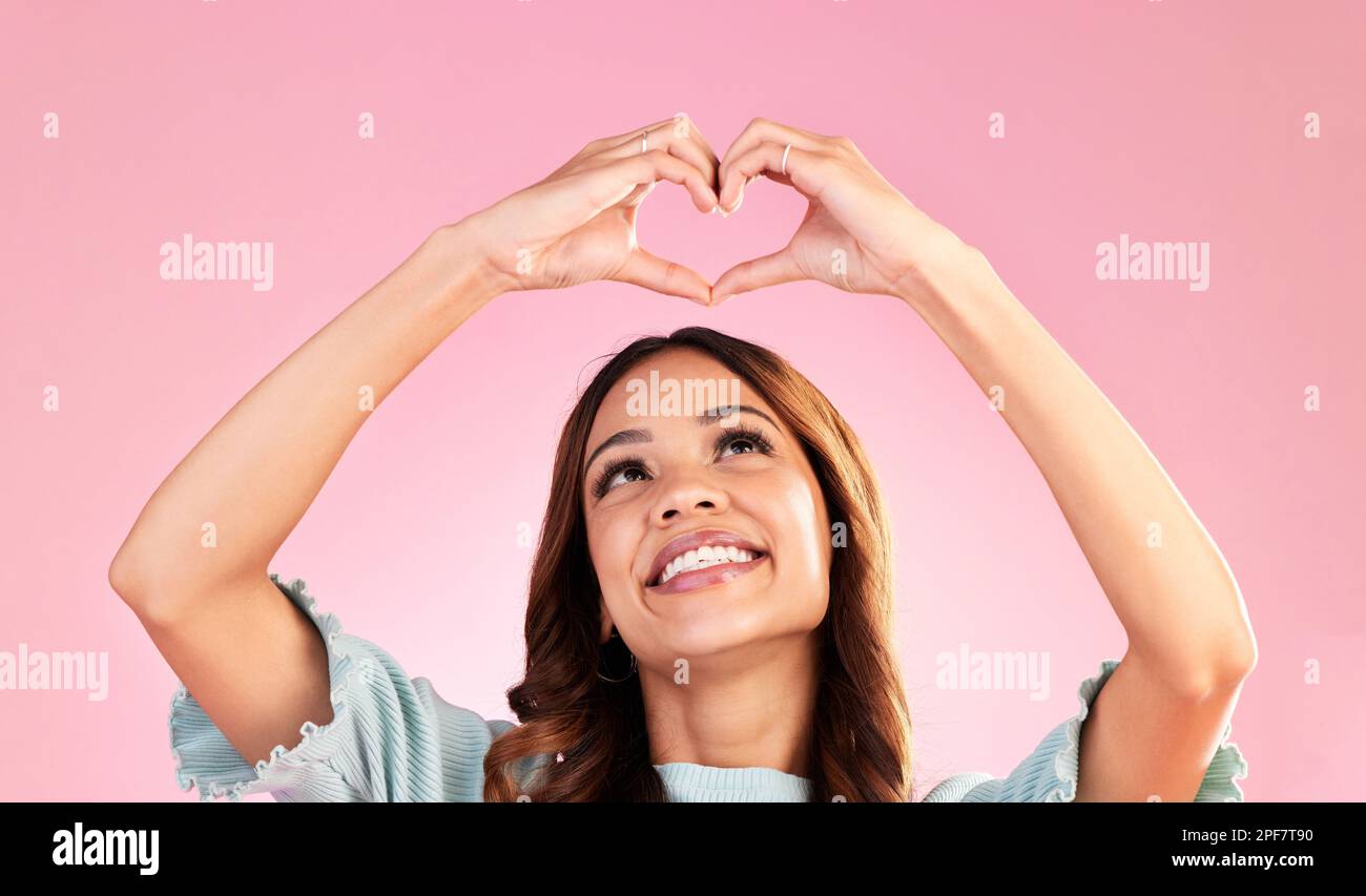 Happy, heart hands and smile with woman in studio for romance, positive ...