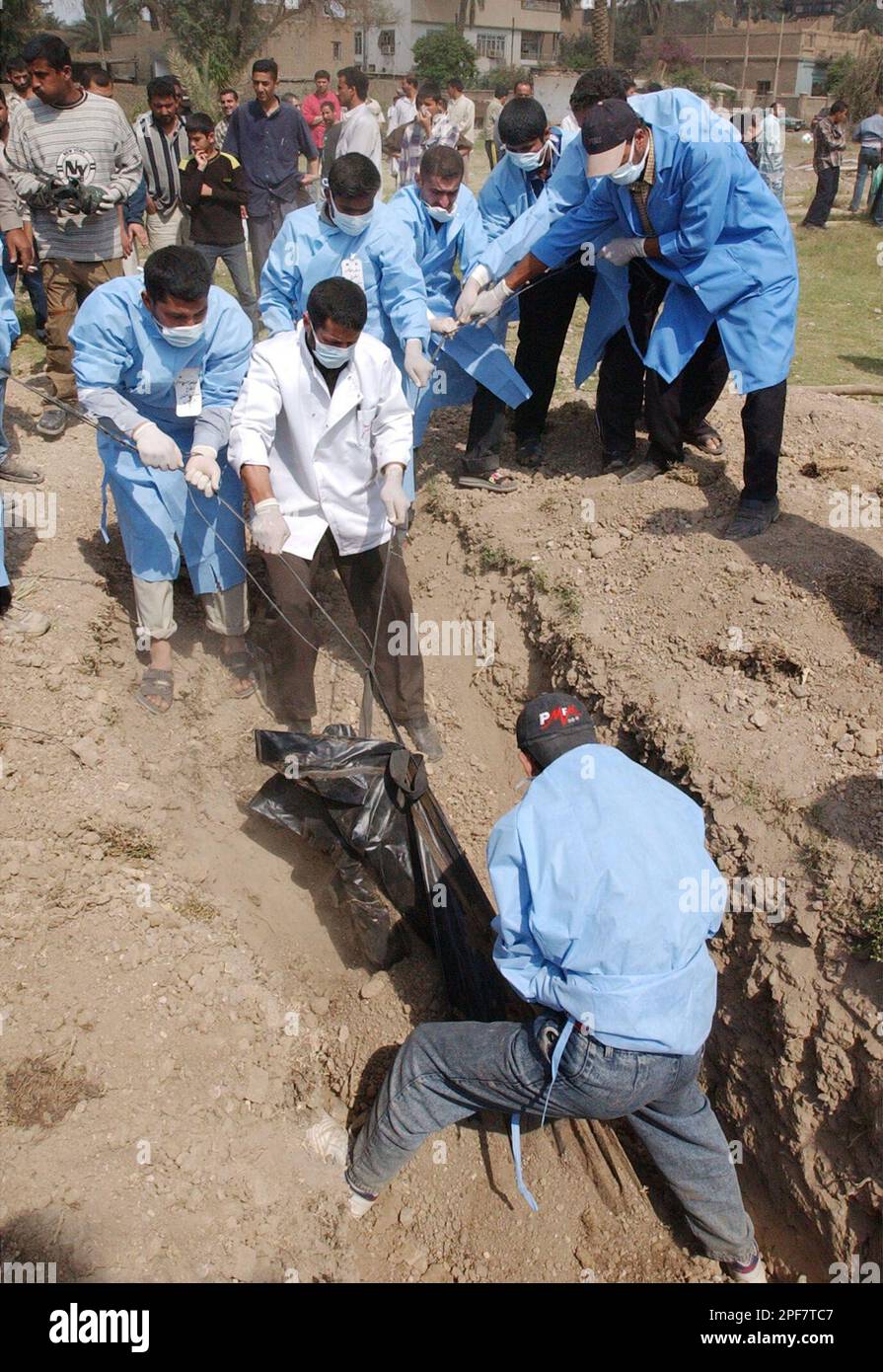 Iraqi nurses, wearing masks as they remove the bodies of dead Arab ...