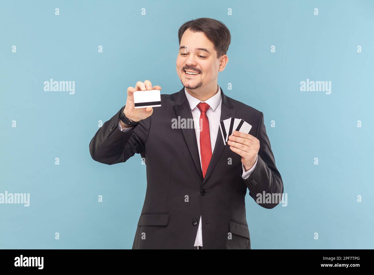 Portrait of delighted smiling greedy man with mustache standing holding ...