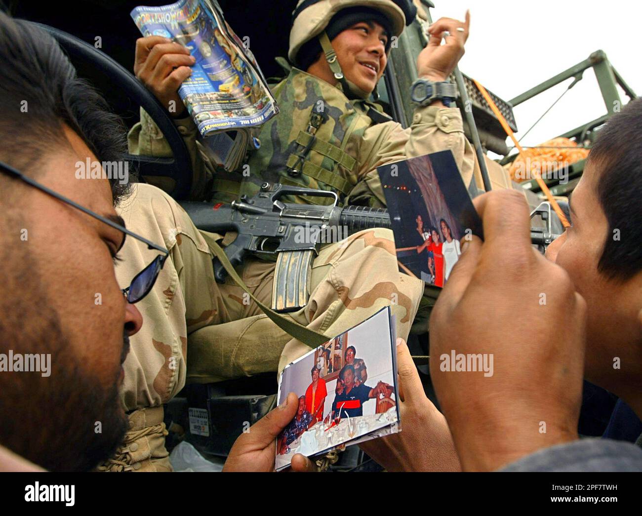 U.S. Marine Lcpl J.E. Sabalboro, 24, from Guam, holding a car magazine ...