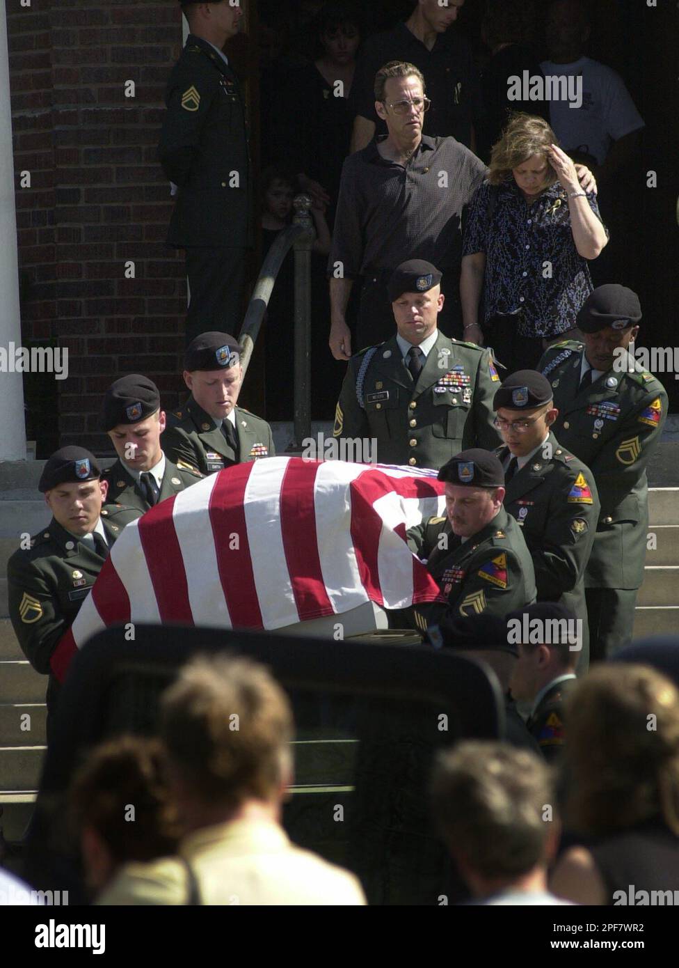 James Butler and his wife Cynthia, background, follow the casket of ...