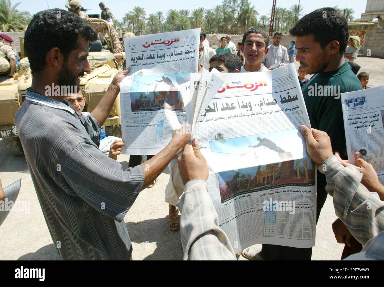 Iraqis read newspapers distributed by U.S.Marine PysOps officers ...