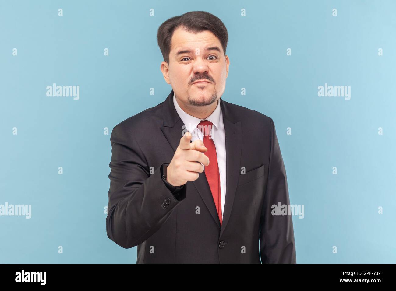 Portrait of sad upset man with mustache standing indicating at you ...