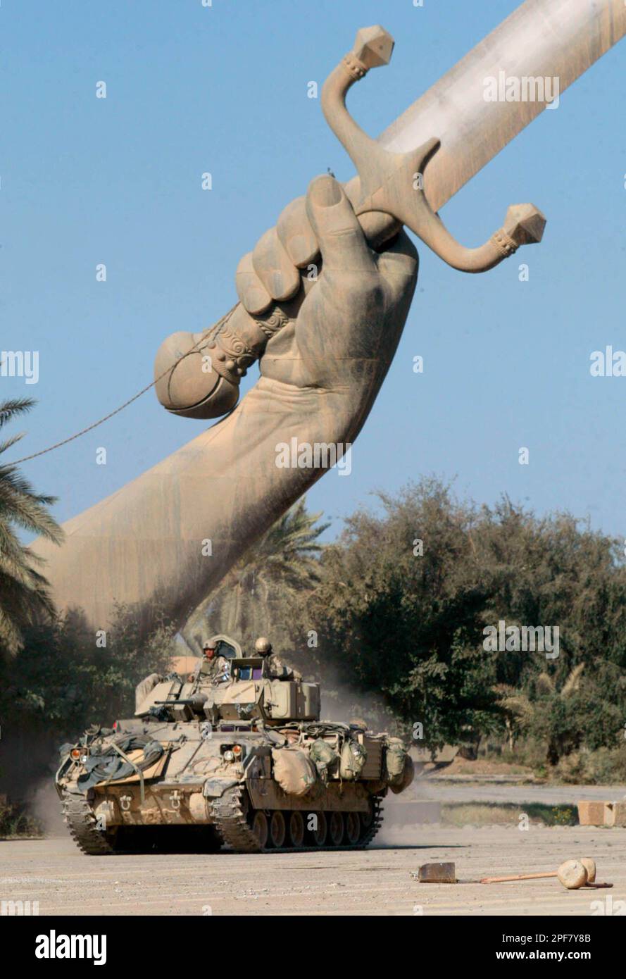 A Bradley fighting vehicle drives under a massive arch of swords at ...