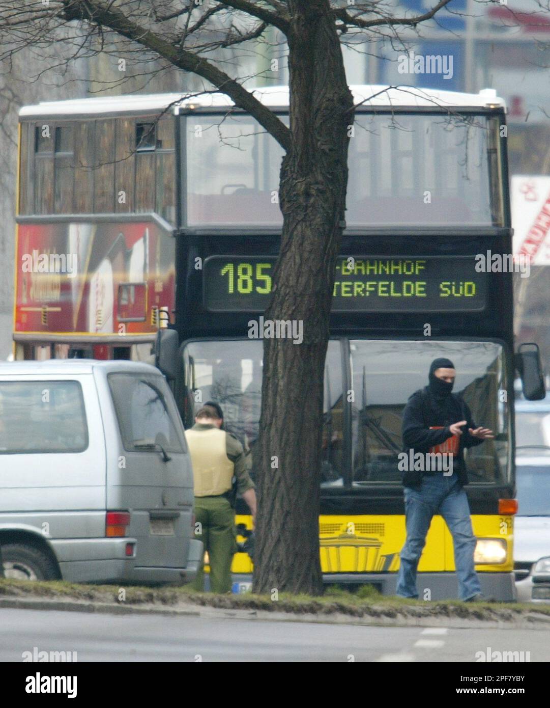 A hooded police officer walks away from a hijacked city bus after ...