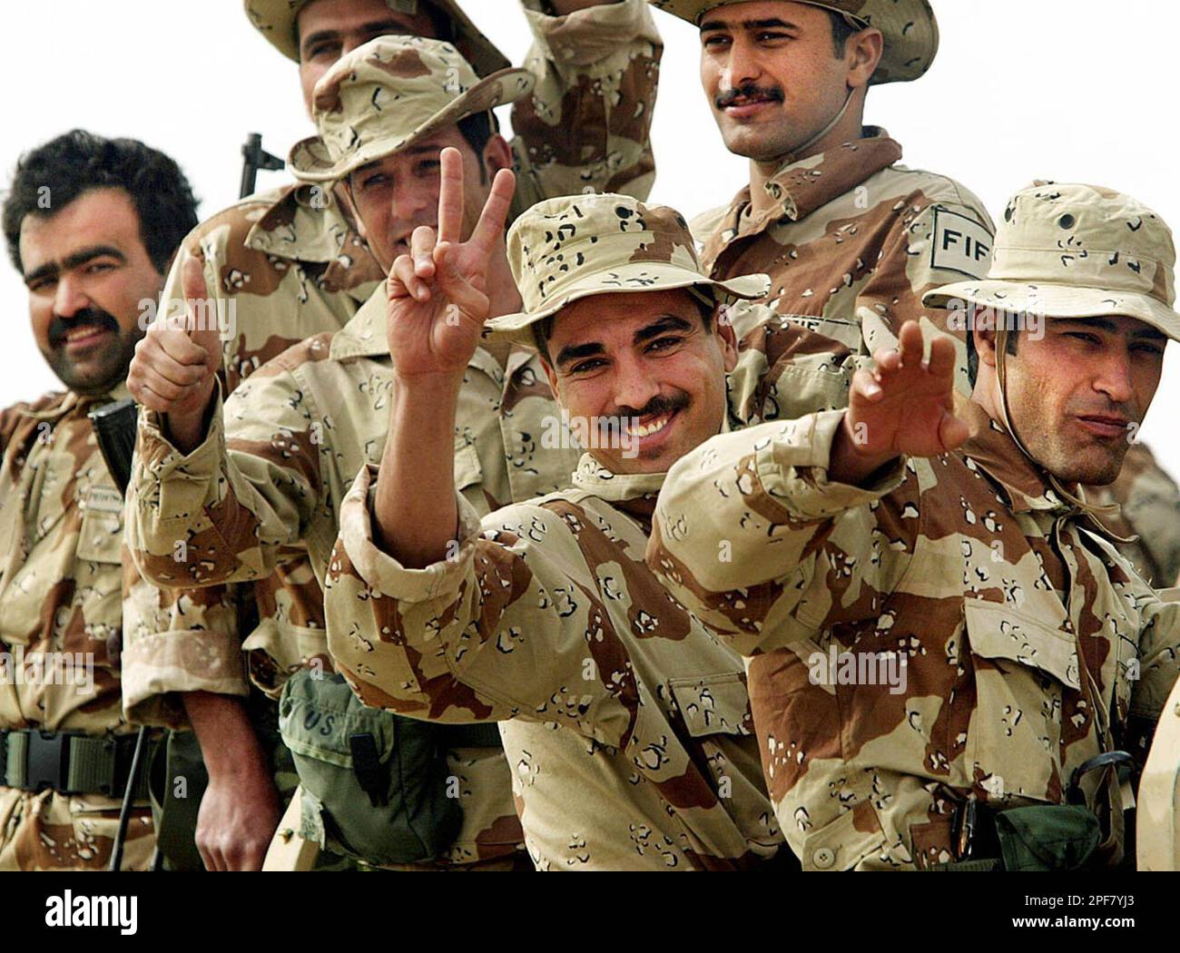 U.S.-trained Free Iraqi Forces soldiers wave their hands from a U.S ...