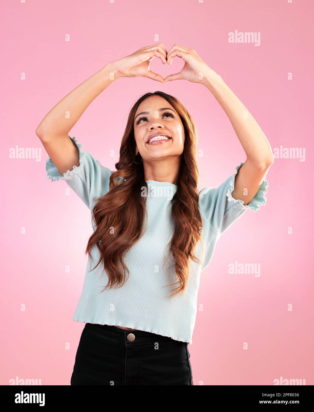 Happy, heart hands and shape with woman in studio for romance, positive ...