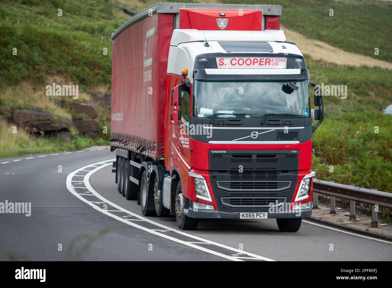 Volvo FH truck pulling a curtainsider trailer takes a downhill bend on ...