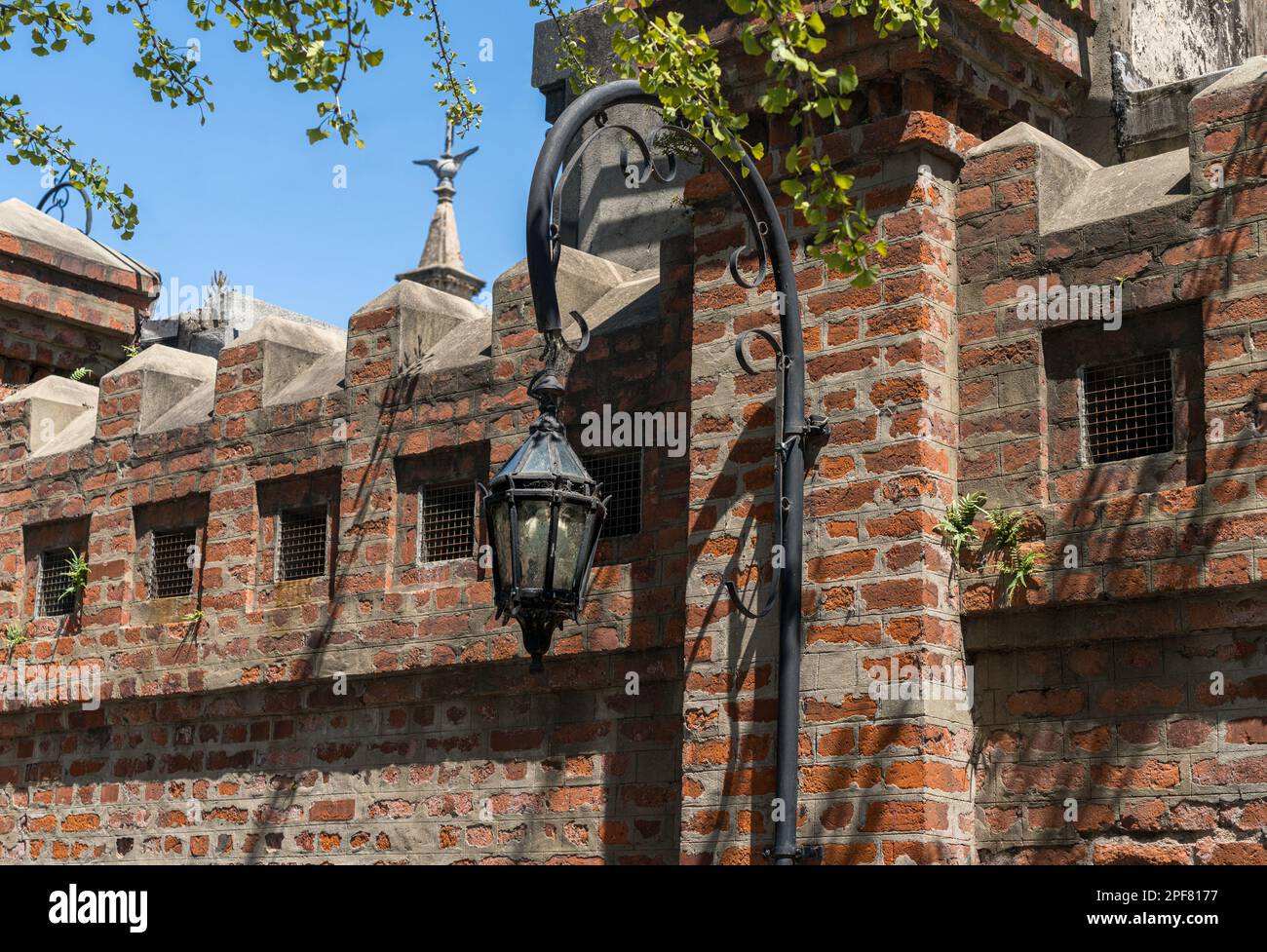 Ornate street lamp by the brick wall surrounding La Recoleta cemetery ...