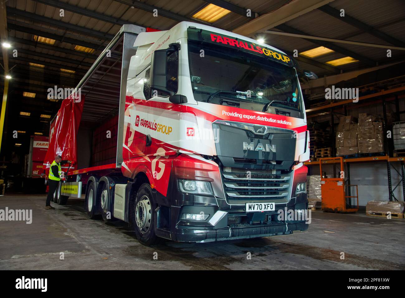 MAN truck with a curtainsider trailer behind loaded in a warehouse ...