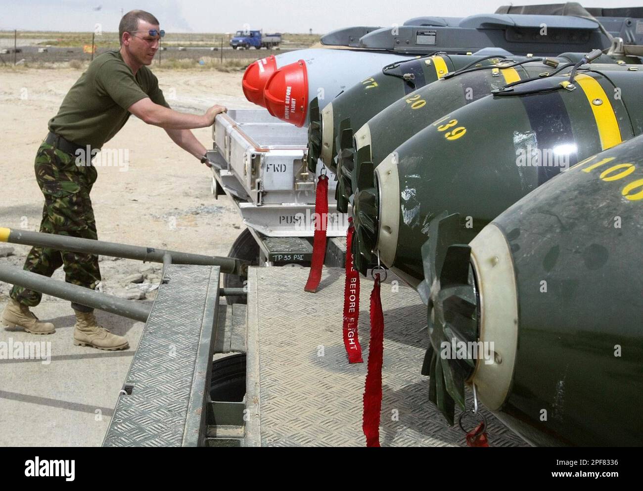 A British Royal Air Force Harrier weapons technician pushes a trolly of ...