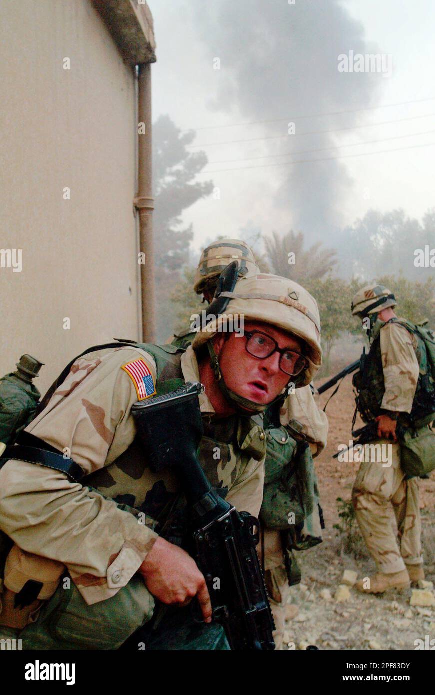 U.S. Army Pfc. Neil Neilson listens as Iraqi ammunition explodes at an ...