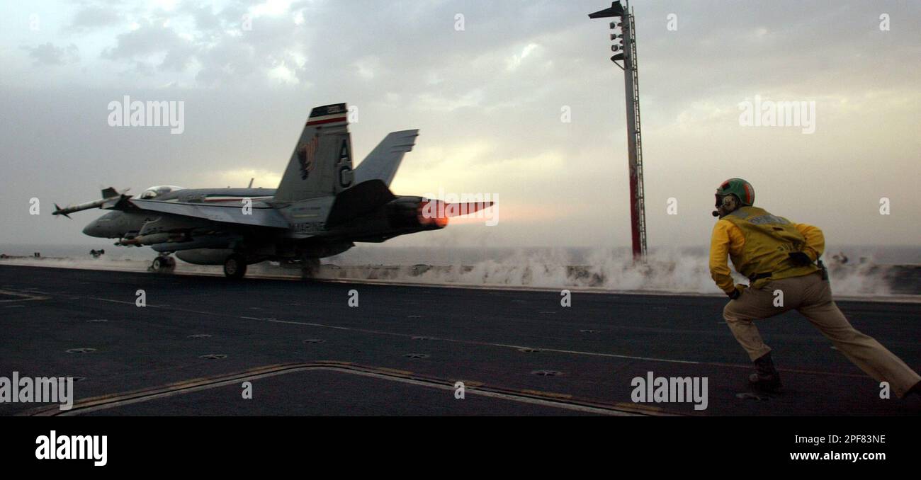 An aircraft handling officer watches a F/A-18 Hornet of the VMFA-115 ...