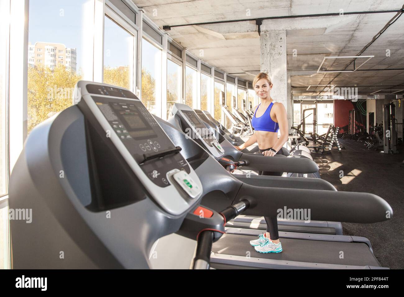 Portrait of sporty smiling happy blonde woman exercising, using ...
