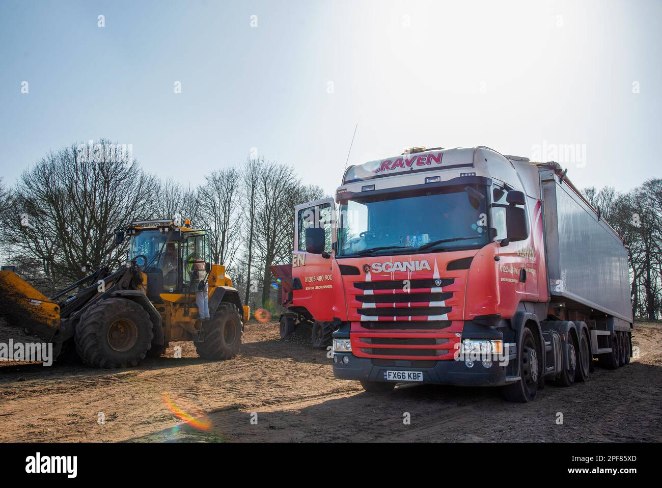 Scania truck pulling a moving floor bulk tipper trailer being loaded ...