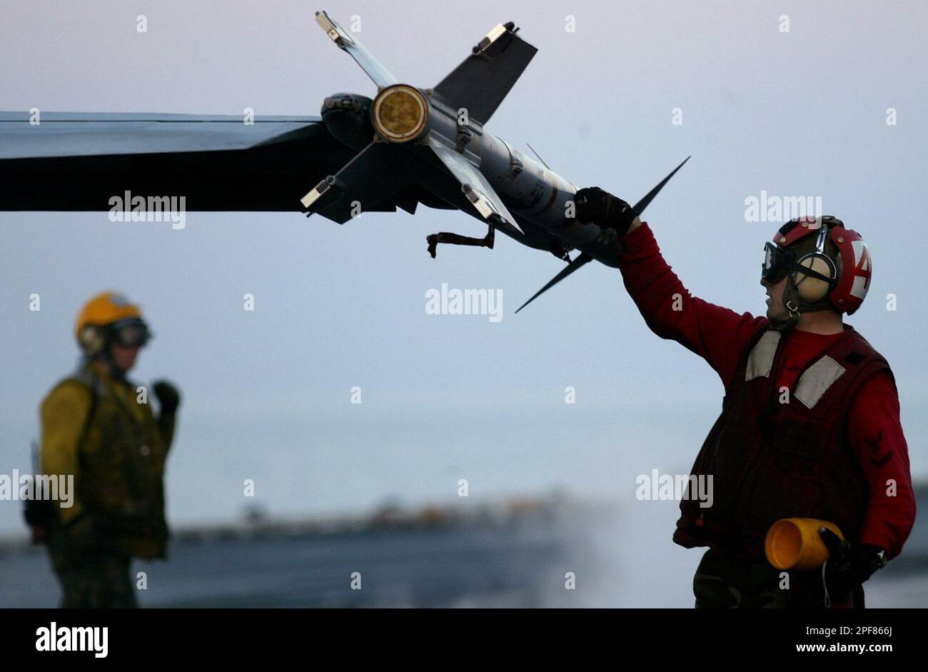 An ordnanceman does a final check of a sidewinder missile prior to the ...