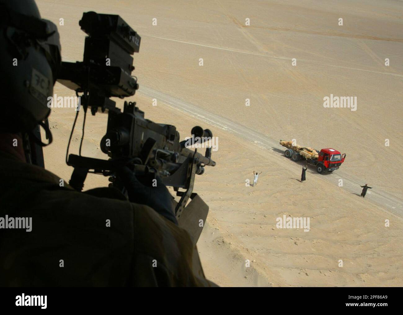 An RAF loadmaster in a Puma helicopter aims his general purpose machine ...