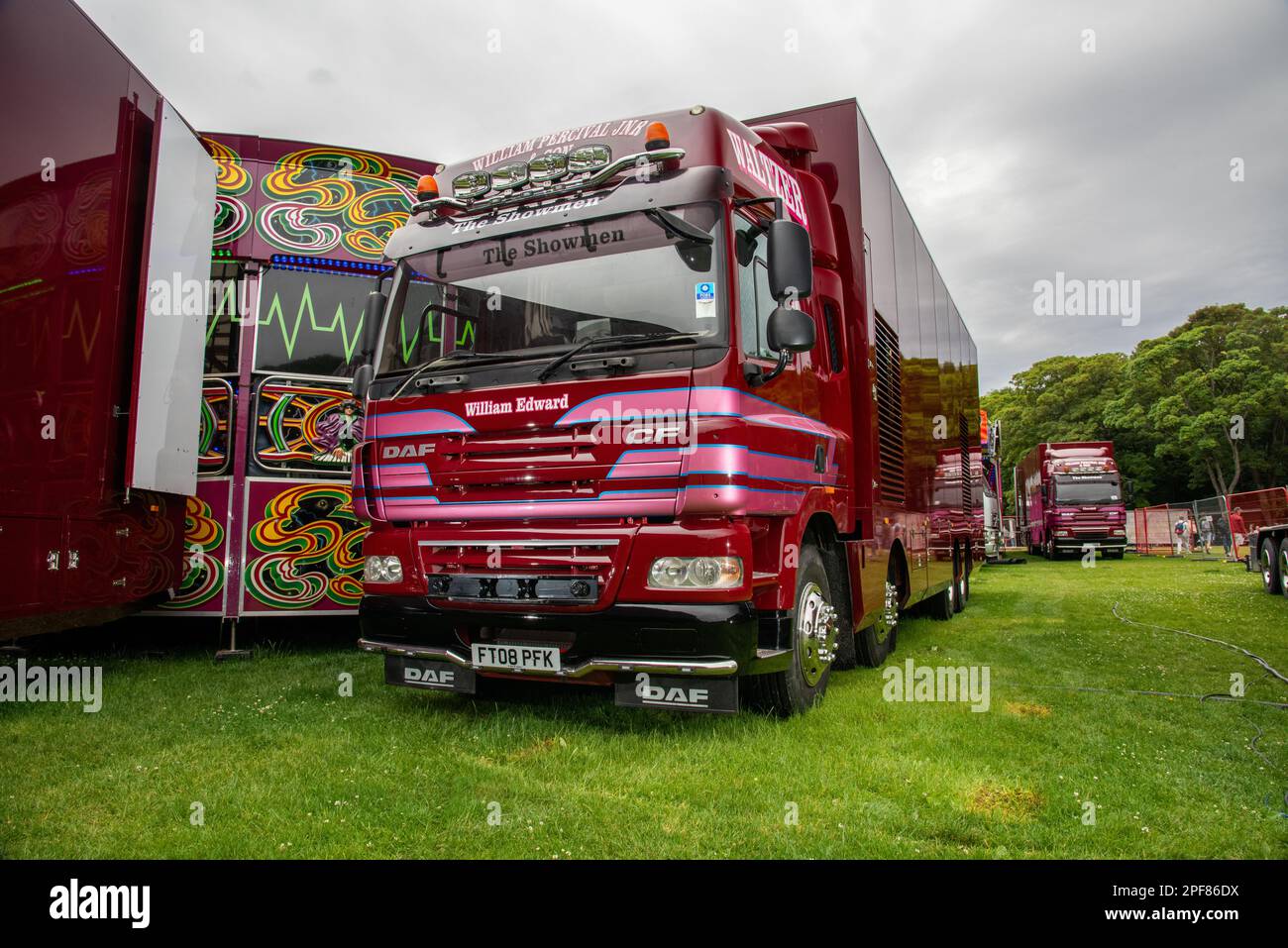 DAF trucks stands behind a fairground ride in a park on a Summer day ...