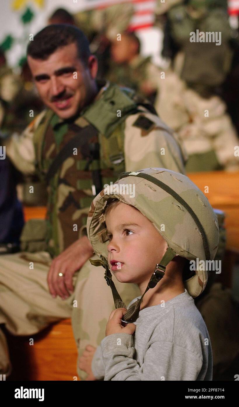 Cody Gates, 4, attempts to wear the helmet of his father, Sgt. Daryl ...