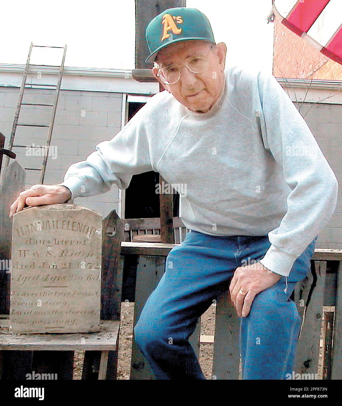 Tom Bender poses with the 1872 tombstone Friday, March 28, 2003, his ...