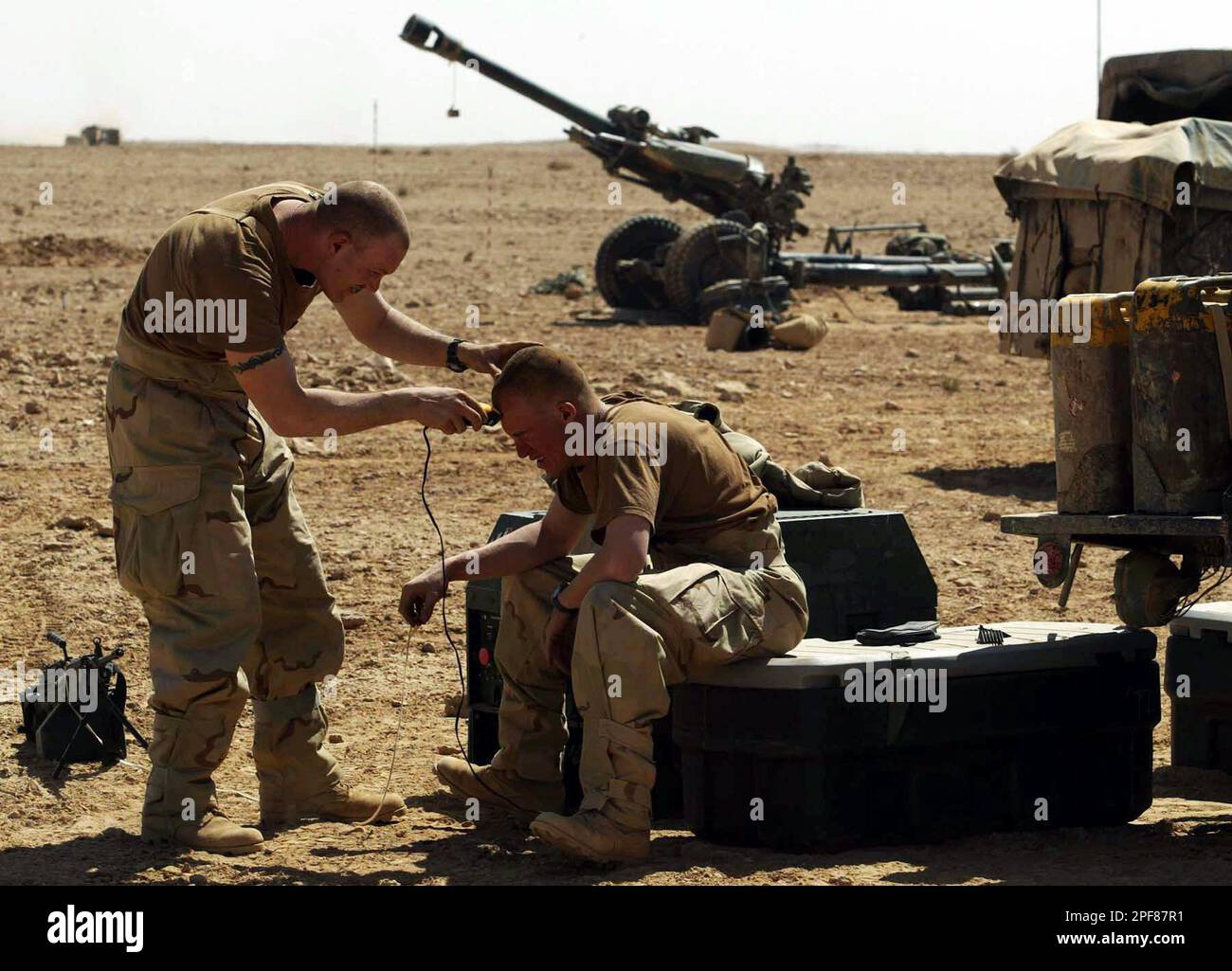 Spc. Joshua Keith of Carterville, Ill., left, shaves the head of Pfc ...