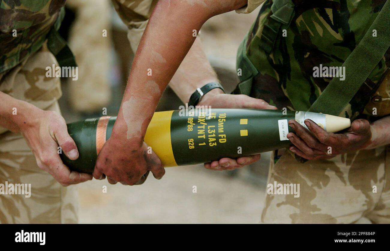A High Explosive 105mm round is passed to a 'loader' prior to firing by ...