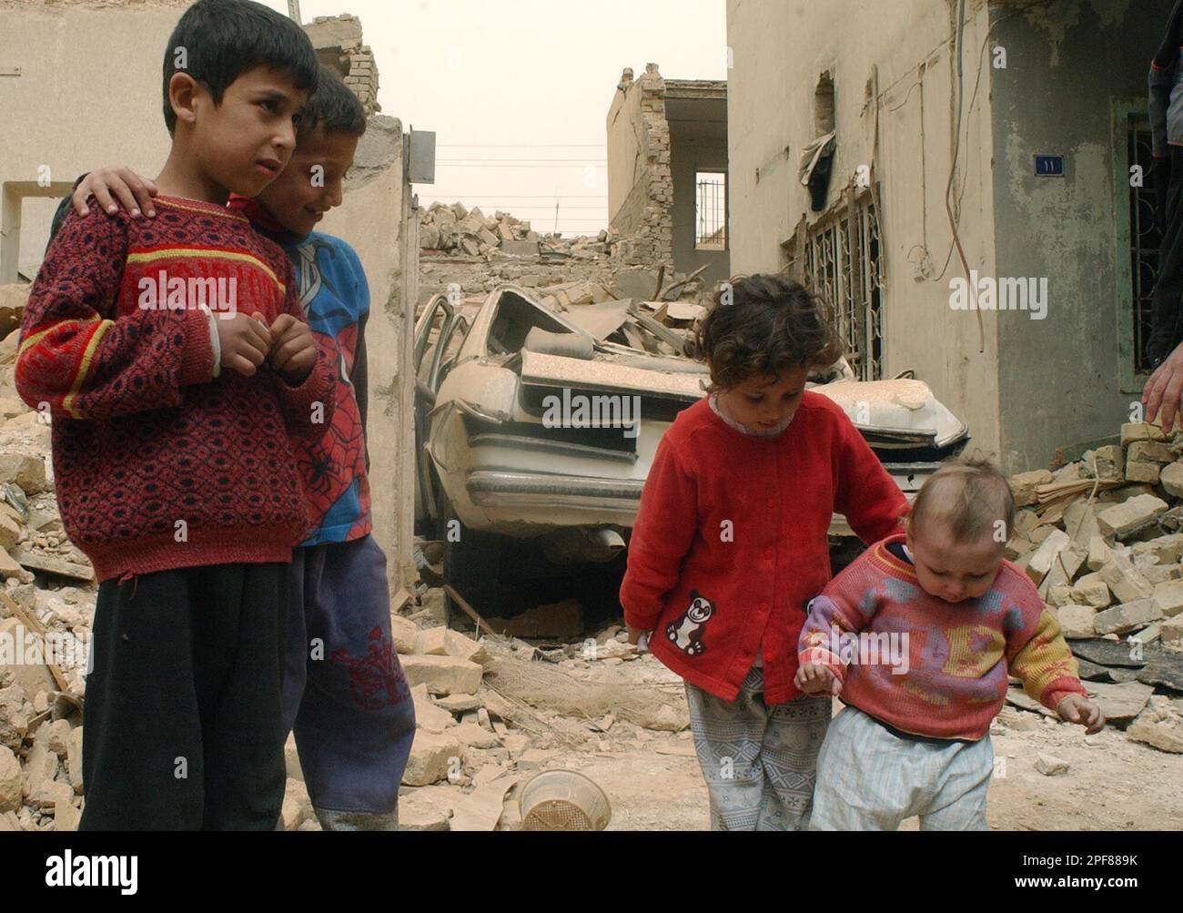Iraqi children walk through the rubble of a house that Iraqi officials ...