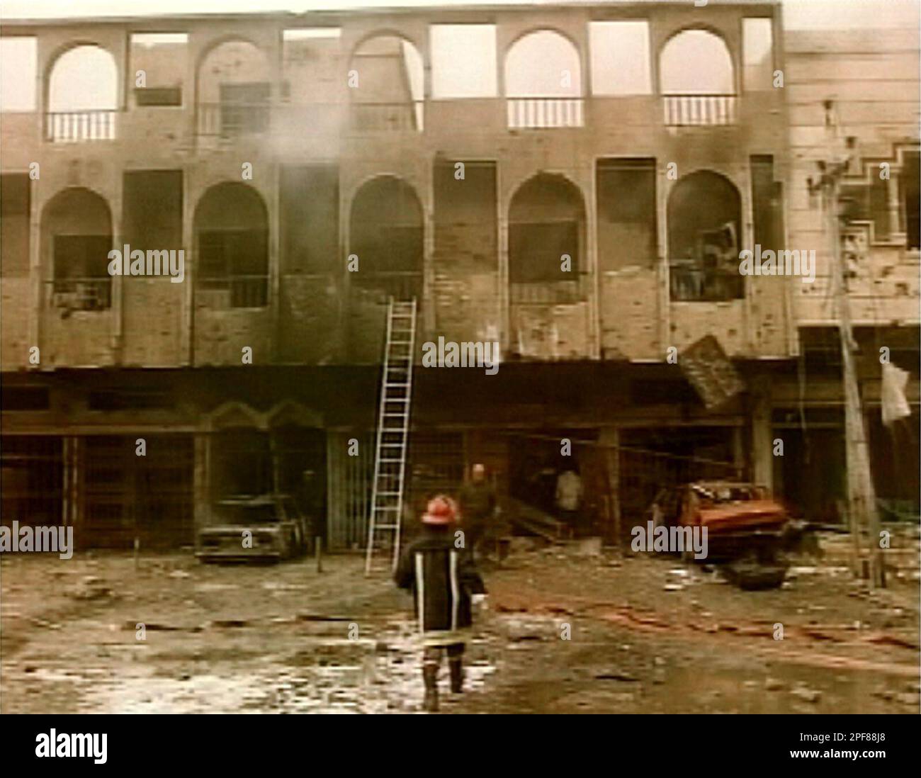 In this image from video, an Iraqi firefighter walks through a damaged ...