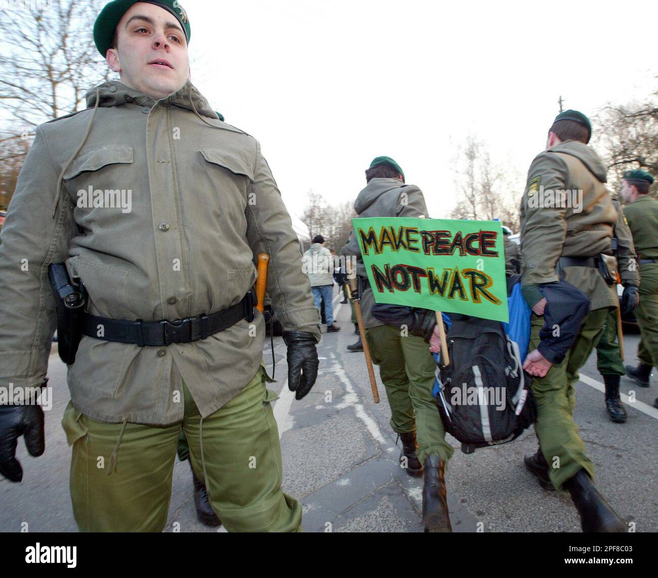 German police officers carry a demonstrator with a banner reading "Make ...