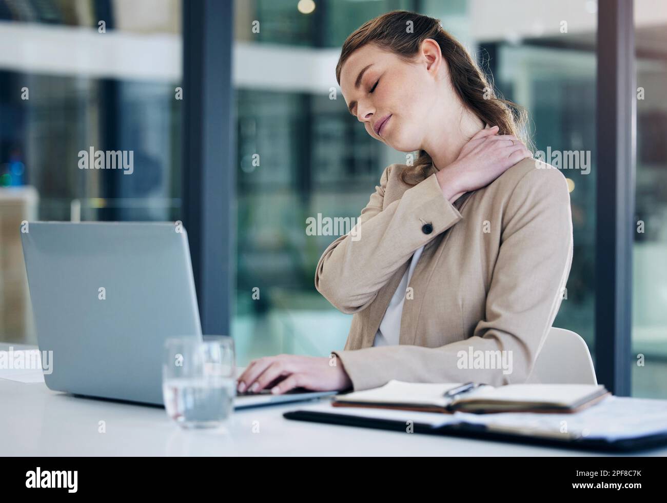 My body is taking a beat with all these deadlines. a young businesswoman experiencing neck pain ...