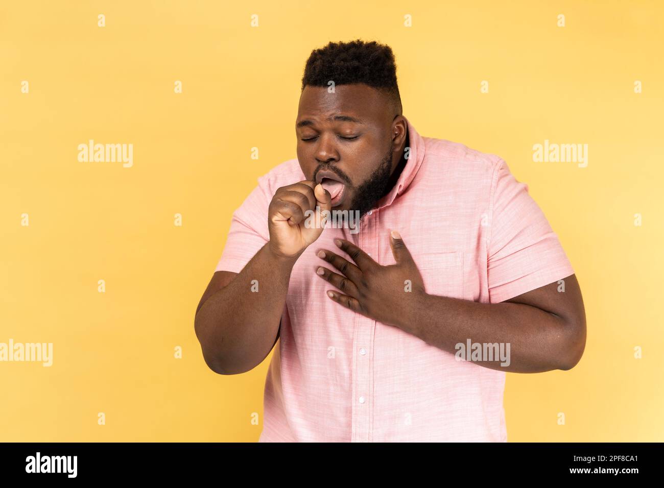 Portrait of sick unhealthy bearded man wearing pink shirt having cough ...