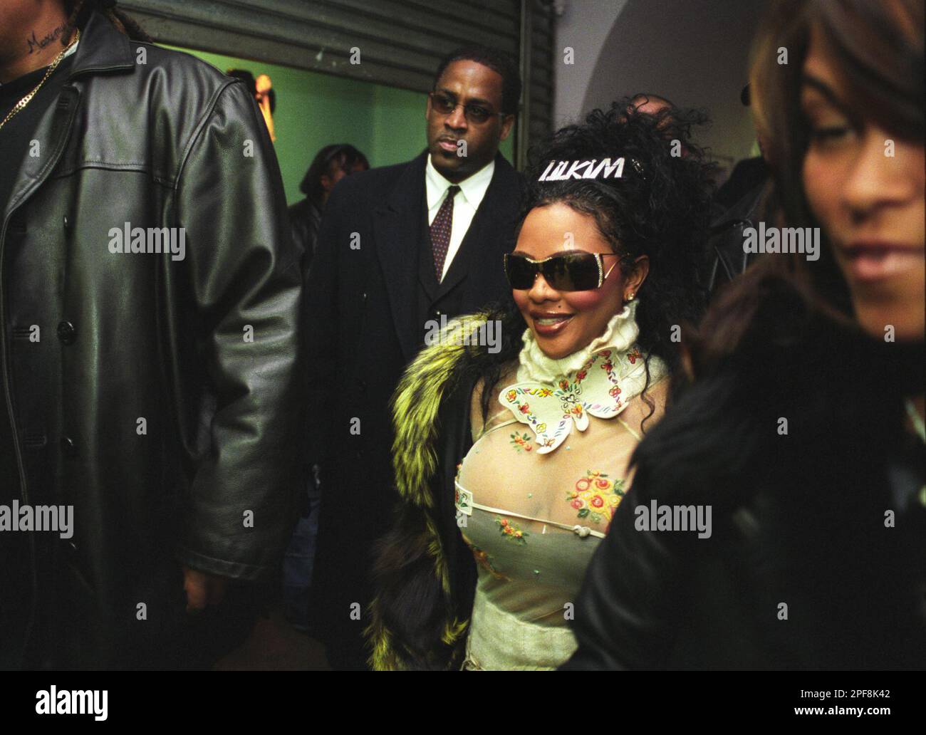 Rapper Lil' Kim walks through the crowd with her bodyguards as she ...
