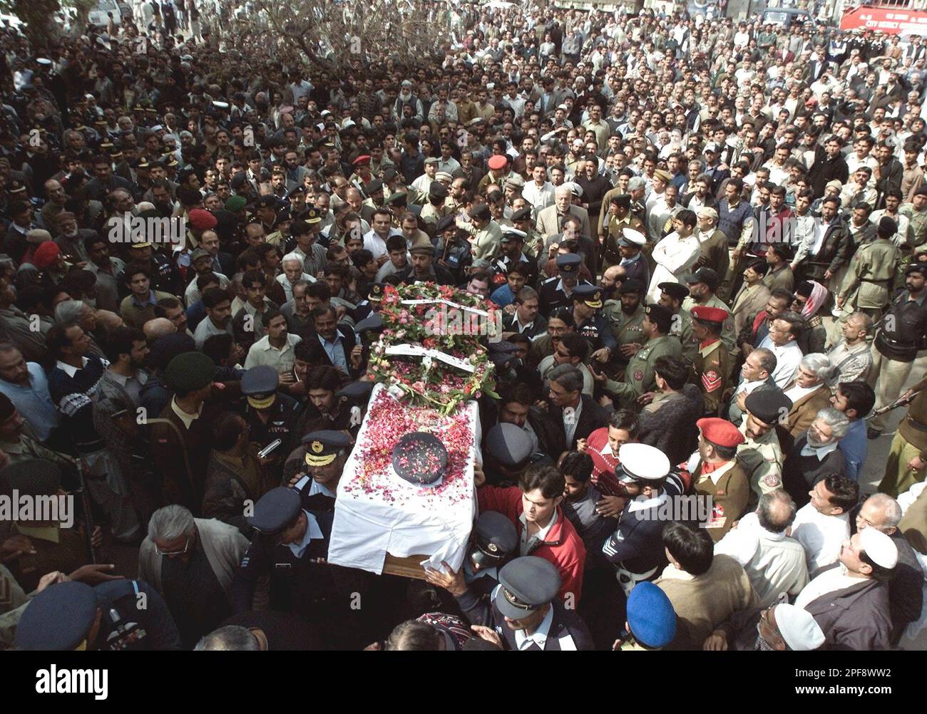 A crowd of mourners surround pallbearers carrying the coffin containing ...