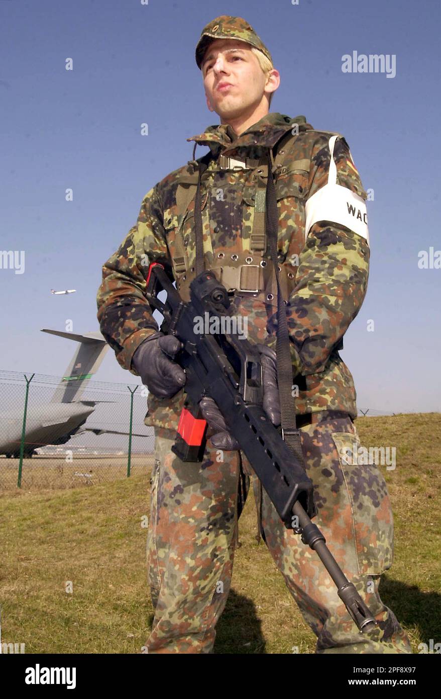 An unidentified German Bundeswehr (Army) soldier patrols along a fence ...