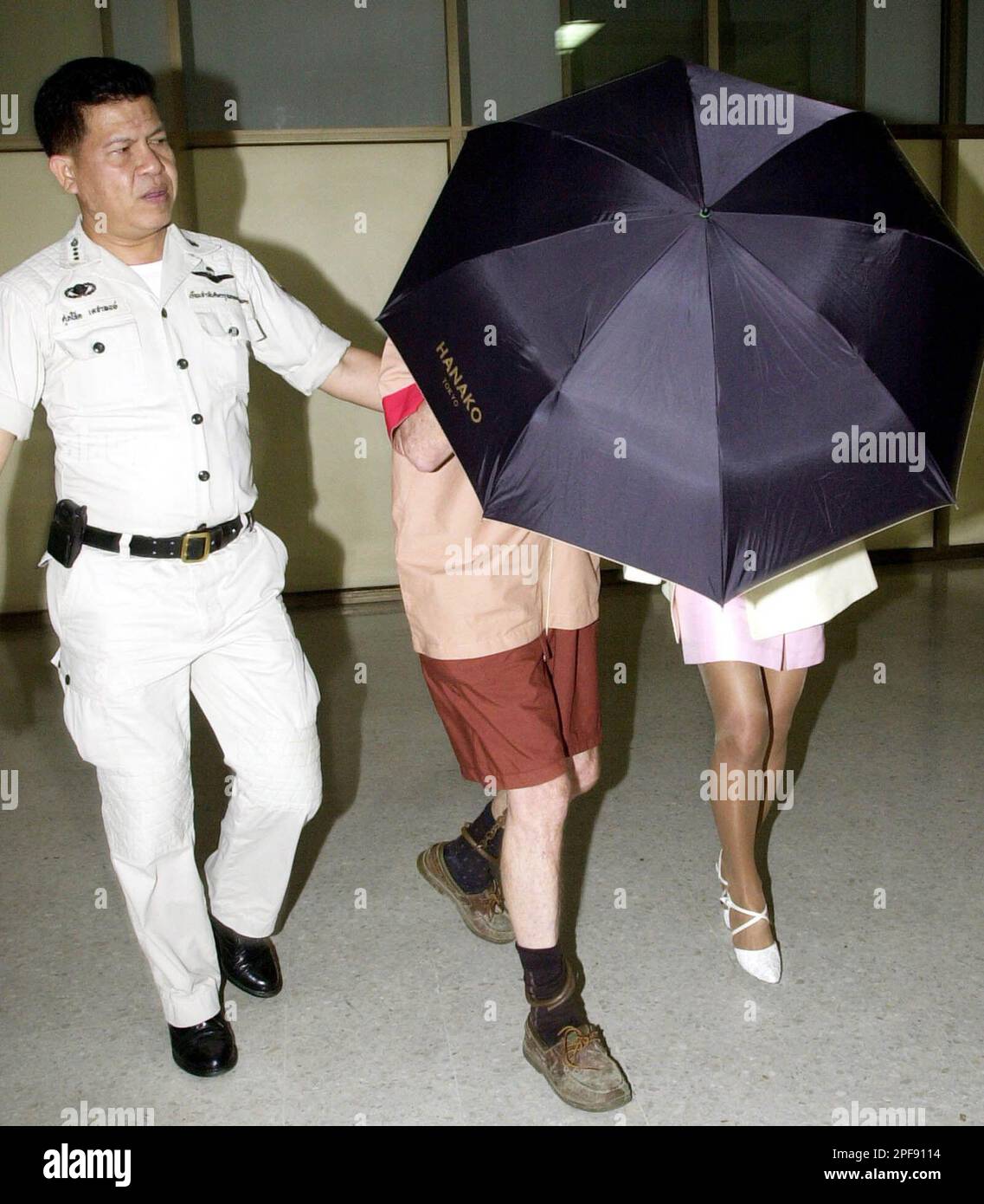 James Vincent Sullivan, 61, from Palm Beach, Fla, center, tries to hide ...