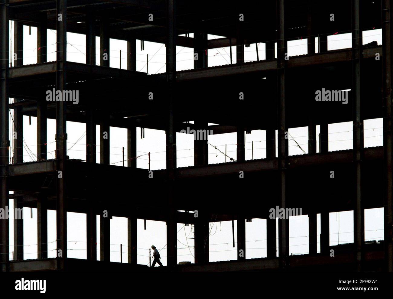 A construction worker walks on the steel framework of the new Fresno ...